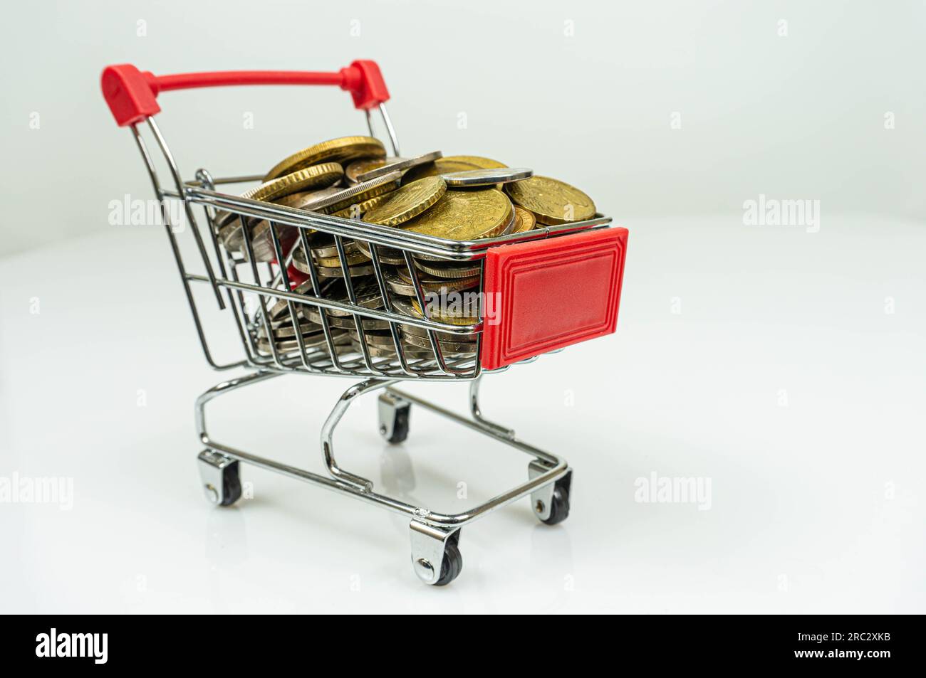 A shop cart full of money, coins. It symbolizes finance, investment ...