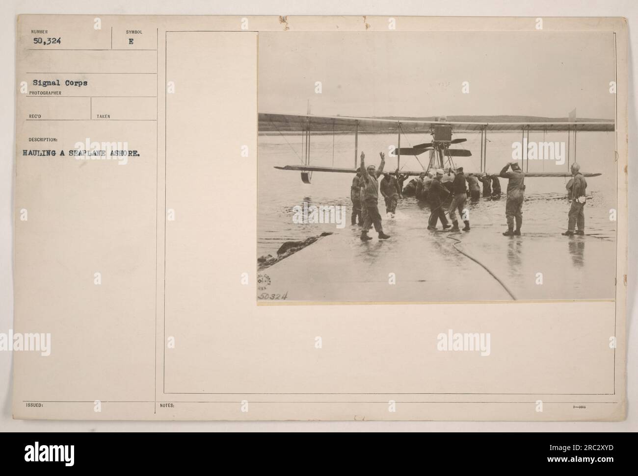 Soldiers work together to haul a seaplane ashore during World War One ...