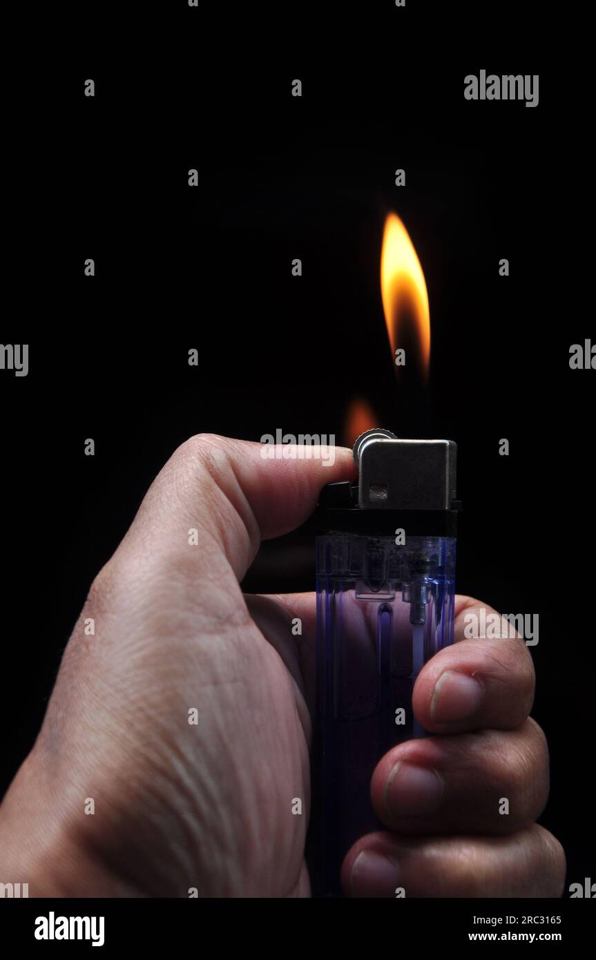 Turn on a gasoline lighter on a black background Stock Photo - Alamy