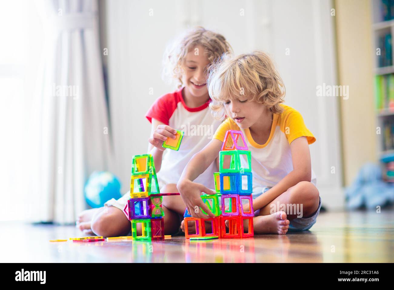 Child playing with magnetic building blocks. Little boy building tower ...