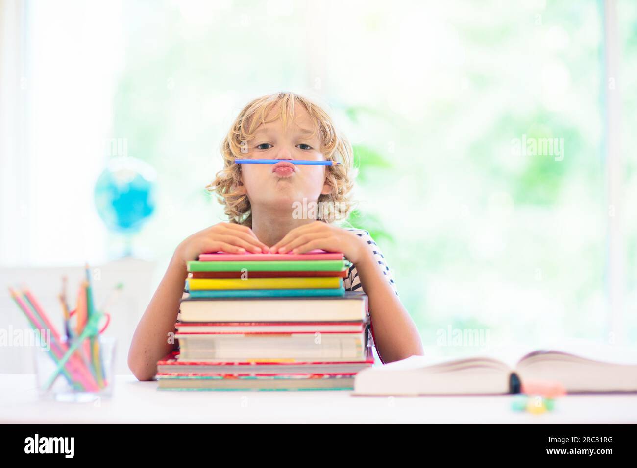 Child doing homework at home. Little kid with colorful books reading ...
