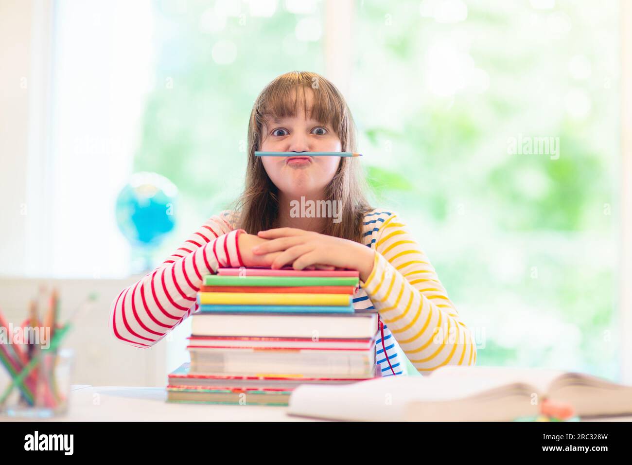Child doing homework at home. Little kid with colorful books reading ...