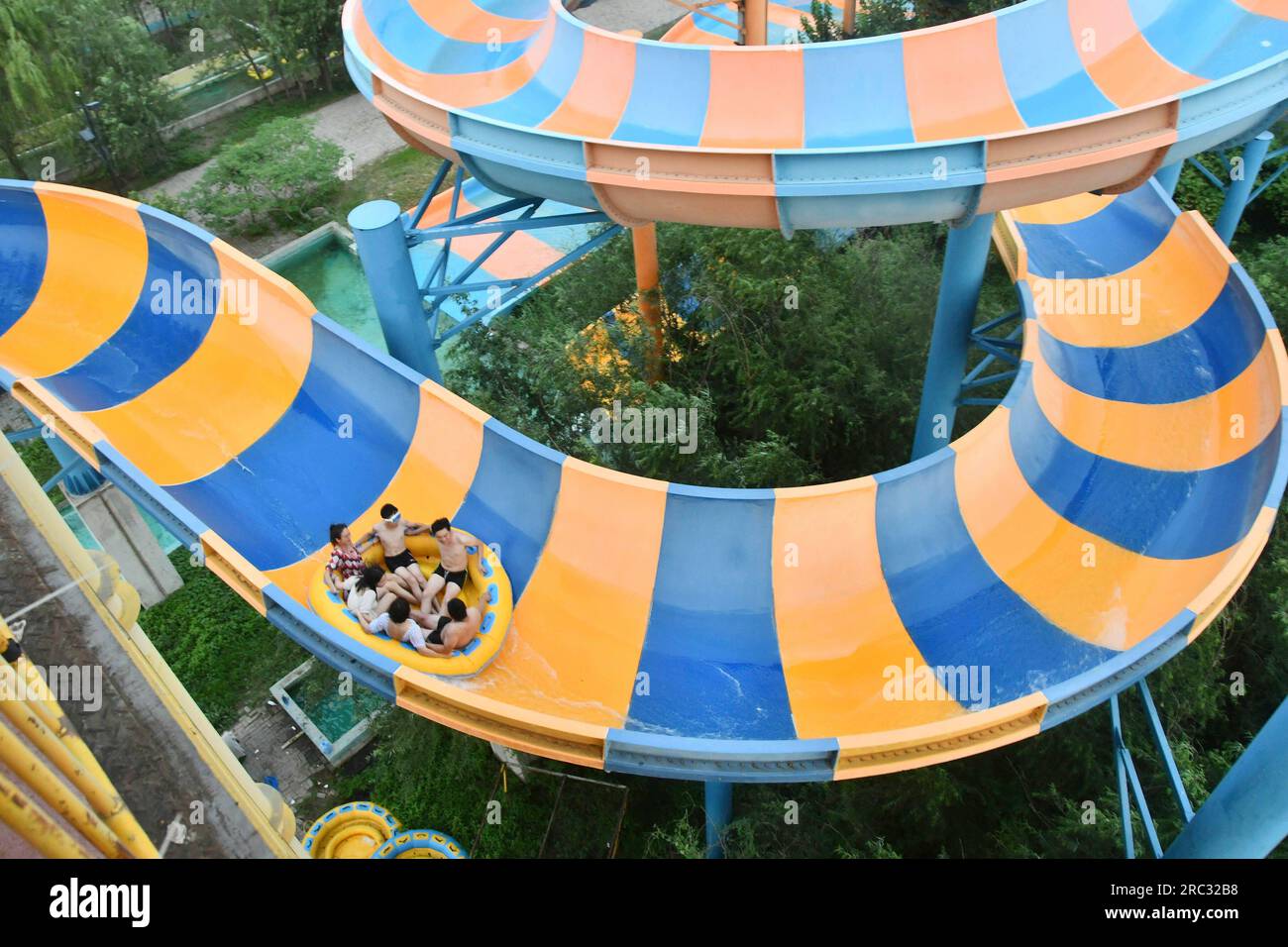 Tourists play a tube slide in a water park in Handan city in north ...