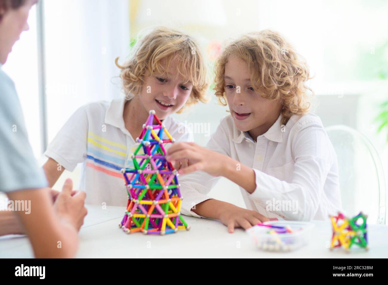 Child playing with magnetic sticks and balls building blocks. Little ...