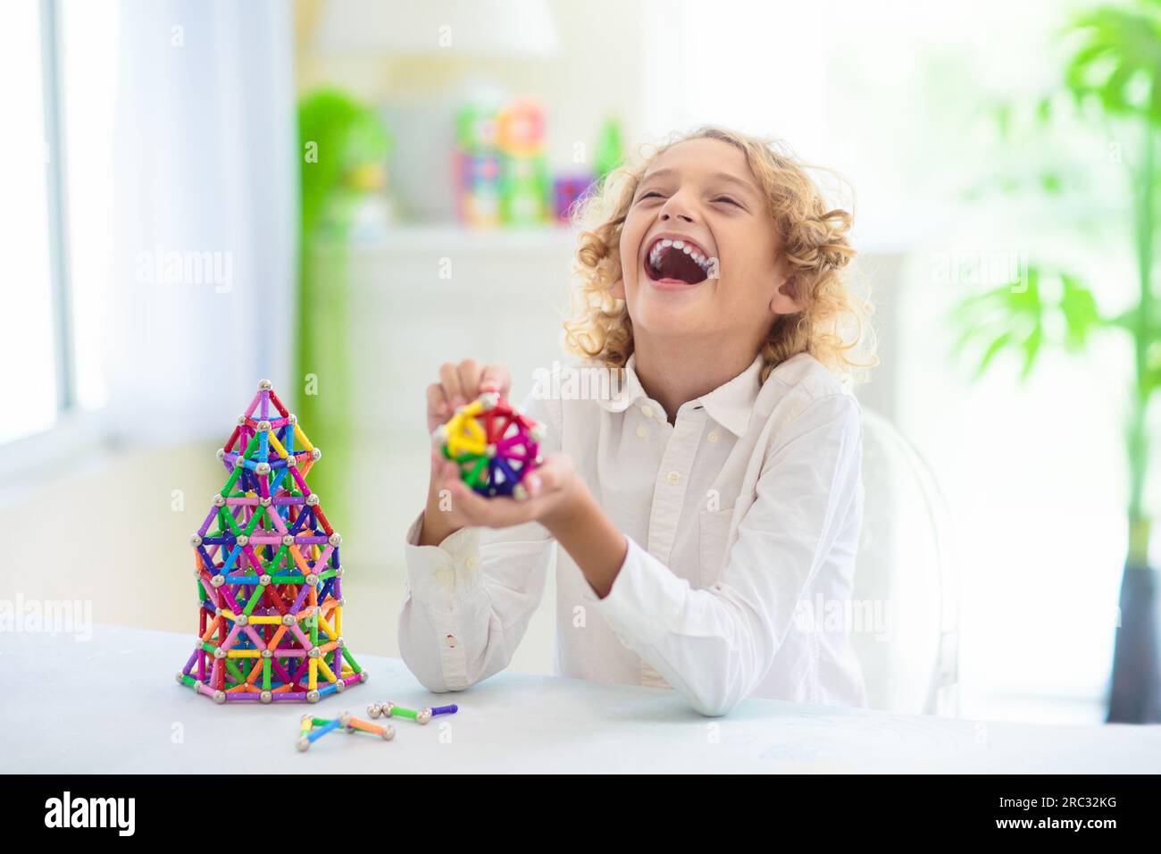 Child playing with magnetic sticks and balls building blocks. Little ...