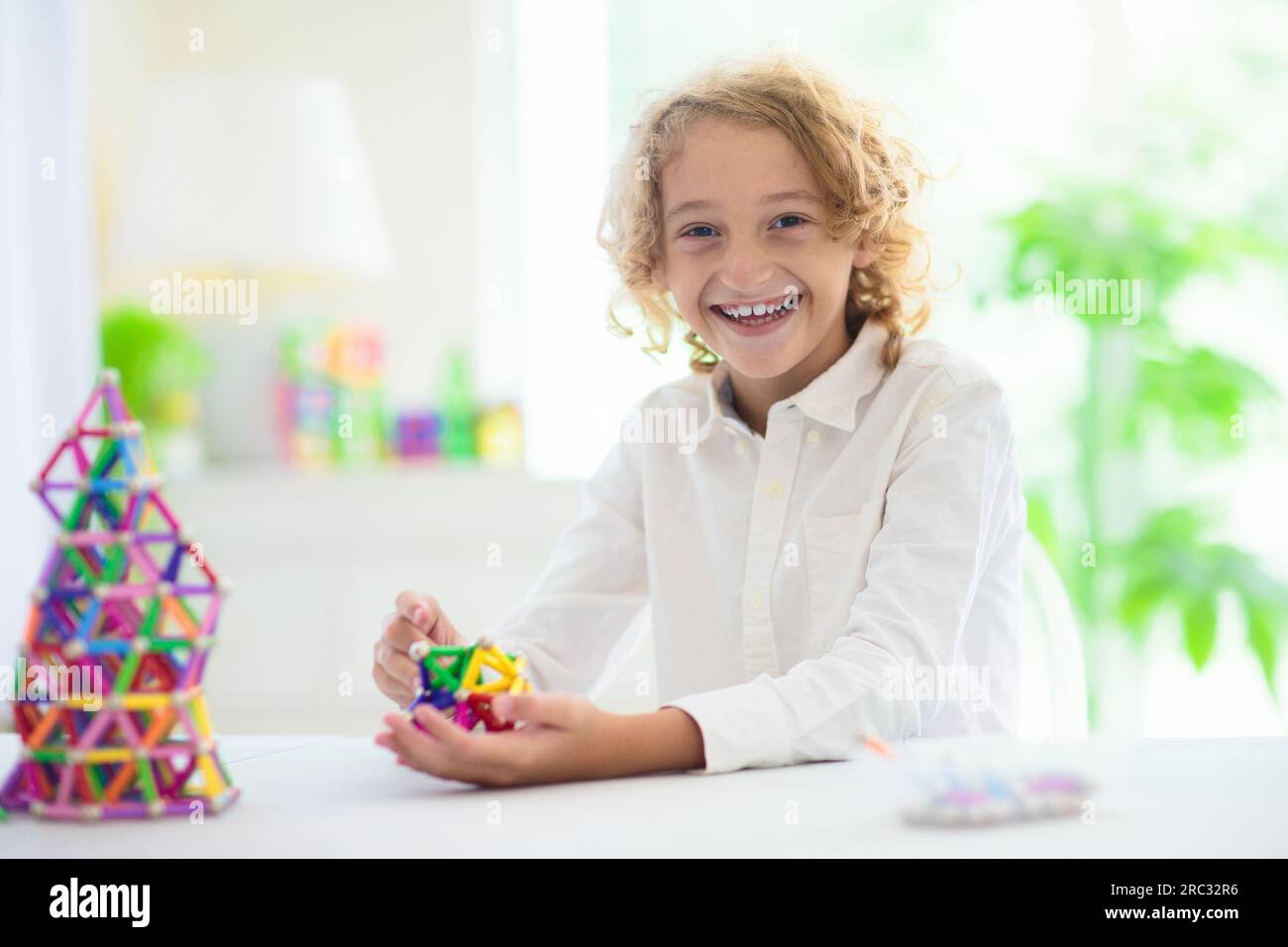 Child playing with magnetic sticks and balls building blocks. Little ...