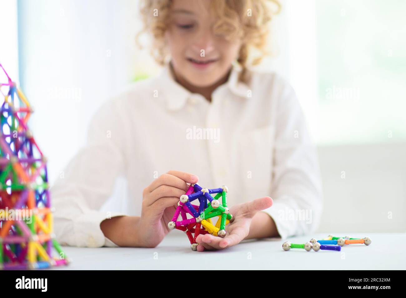 Child playing with magnetic sticks and balls building blocks. Little ...