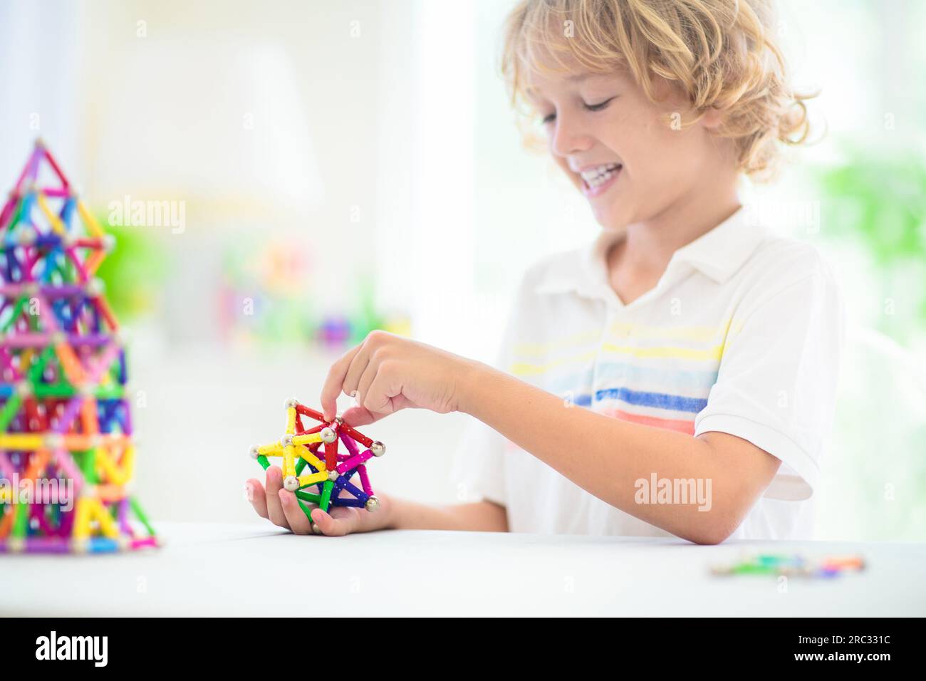 Child playing with magnetic sticks and balls building blocks. Little ...