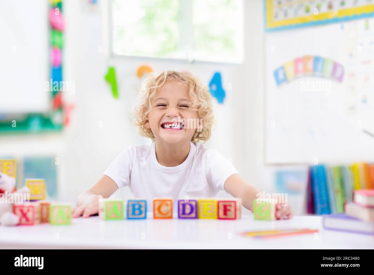 Child learning letters and numbers. Kid with colorful wooden abc blocks ...
