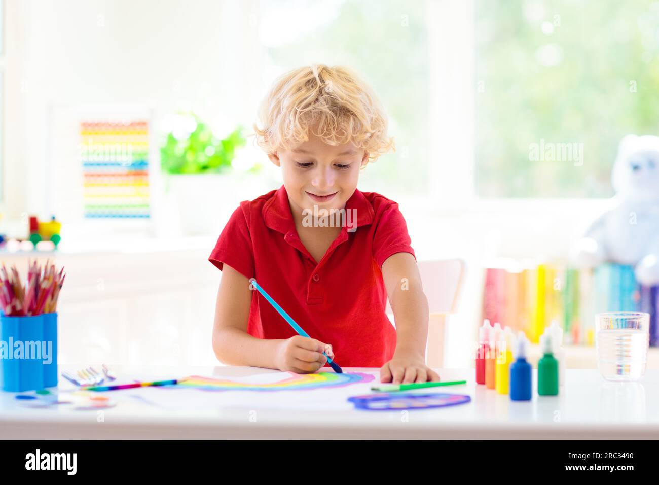 Kids paint. Child painting in white sunny study room. Little boy ...