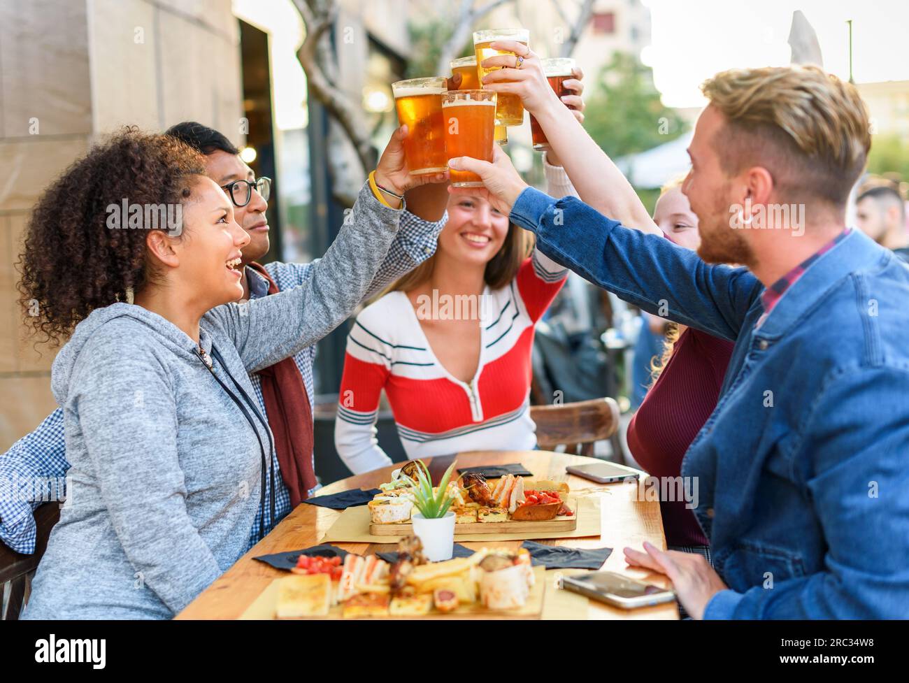Beer glass cheers friends outside hi-res stock photography and images ...