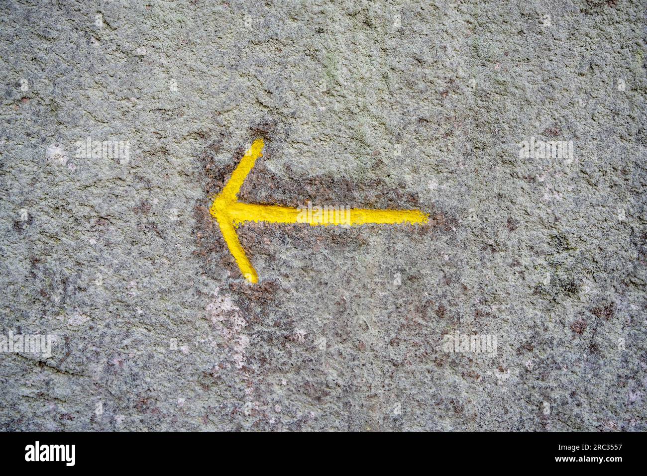 mountain pointer on yellow arrow on a stone close-up, direction ...