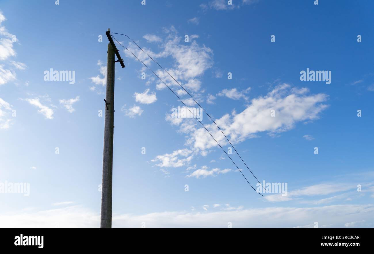 Snapped phone wires on a telegraph pole against a blue sky Stock Photo ...