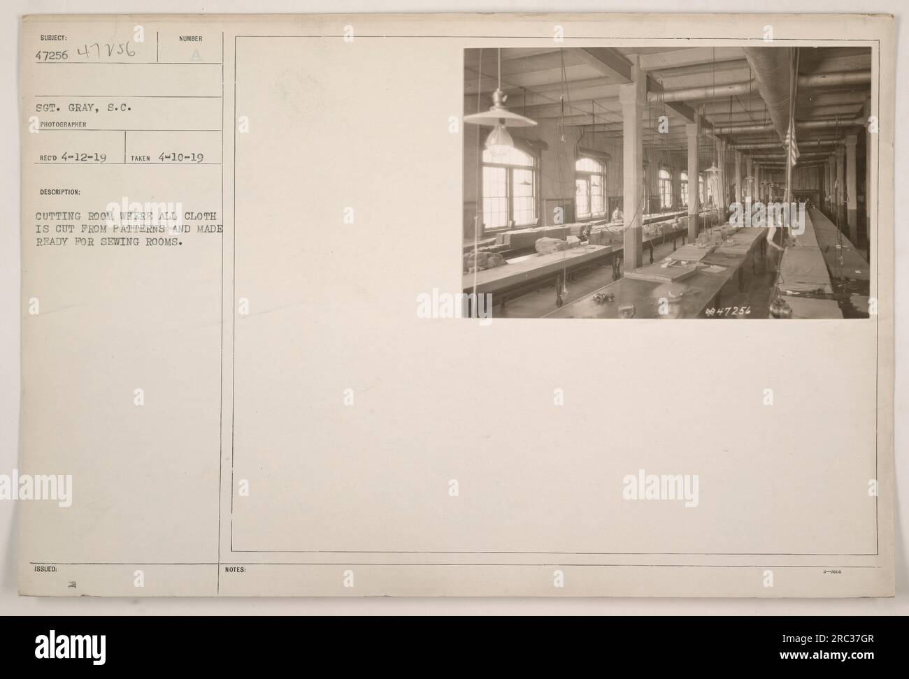 Cutting room in use during World War I where fabric is being cut ...