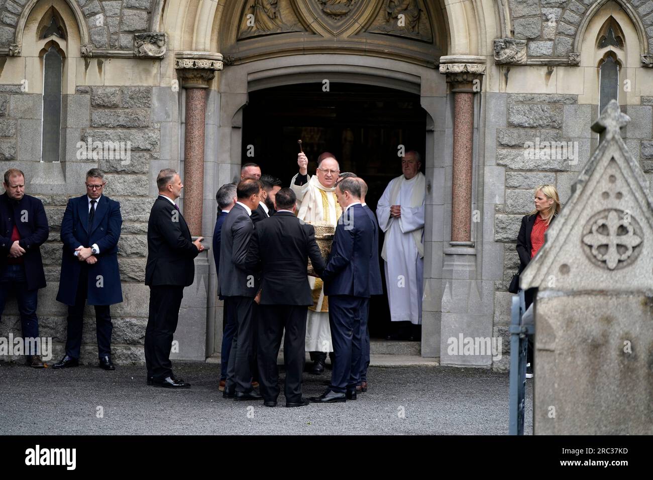 The parish priest sprinkles holy water on the coffin of 18-year-old ...