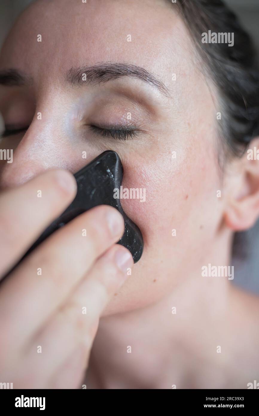 Young Caucasian woman getting facial treatment. Therapist doing skin ...