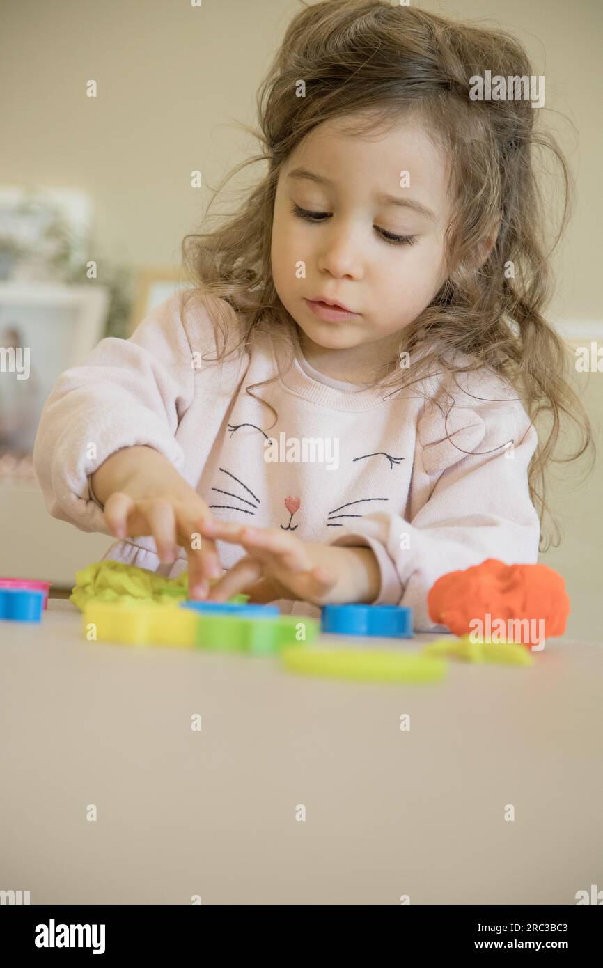 Caucasian child, two or three years old, playing and exercising fine ...