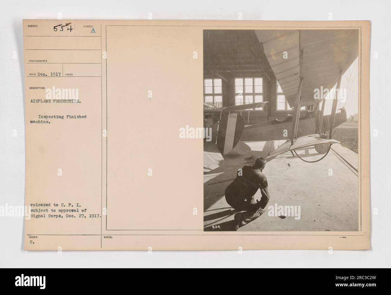 An inspector examines a finished military airplane as part of the ...