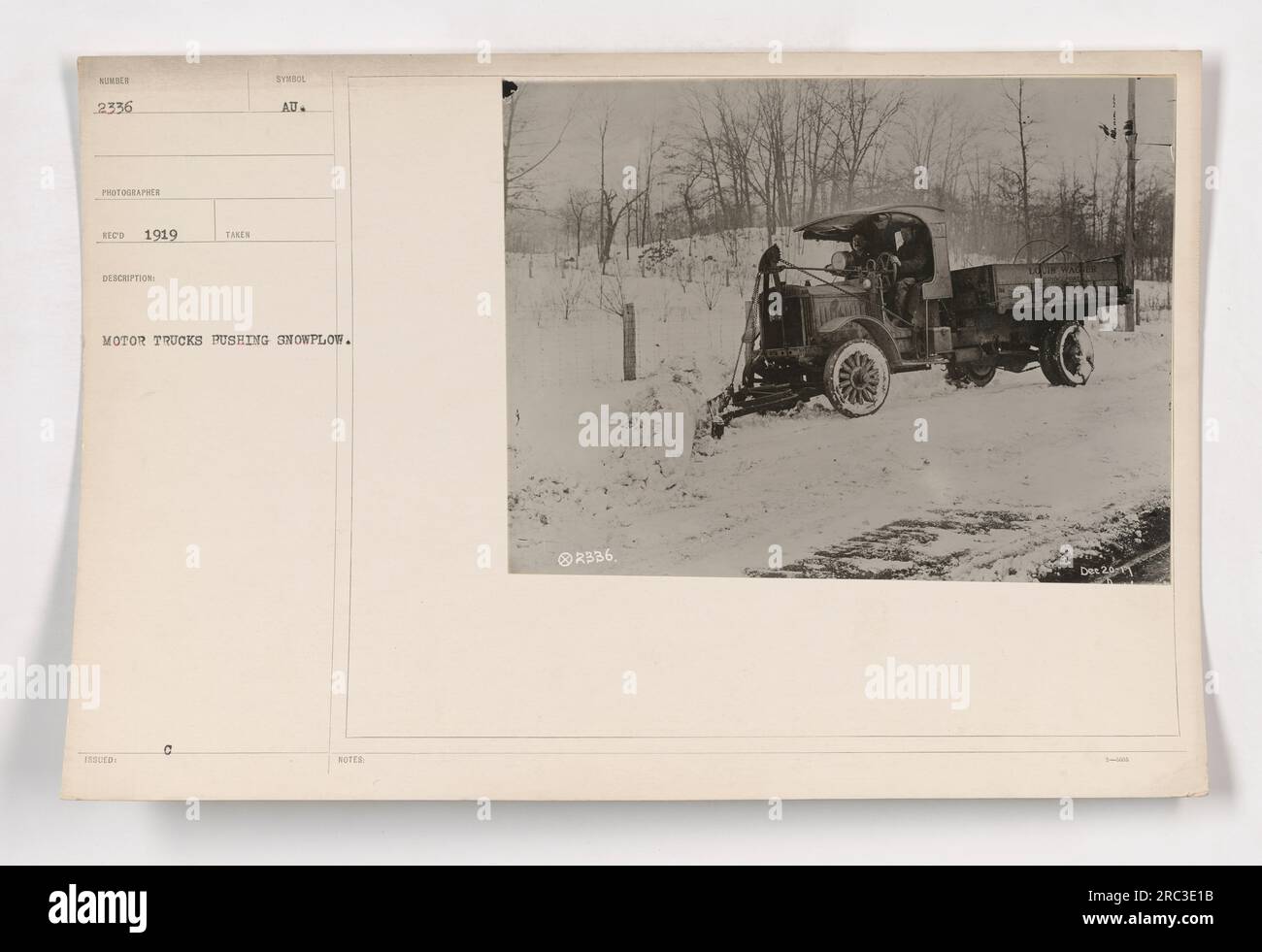 Motor trucks in action, pushing a snowplow to clear a snow-covered road ...