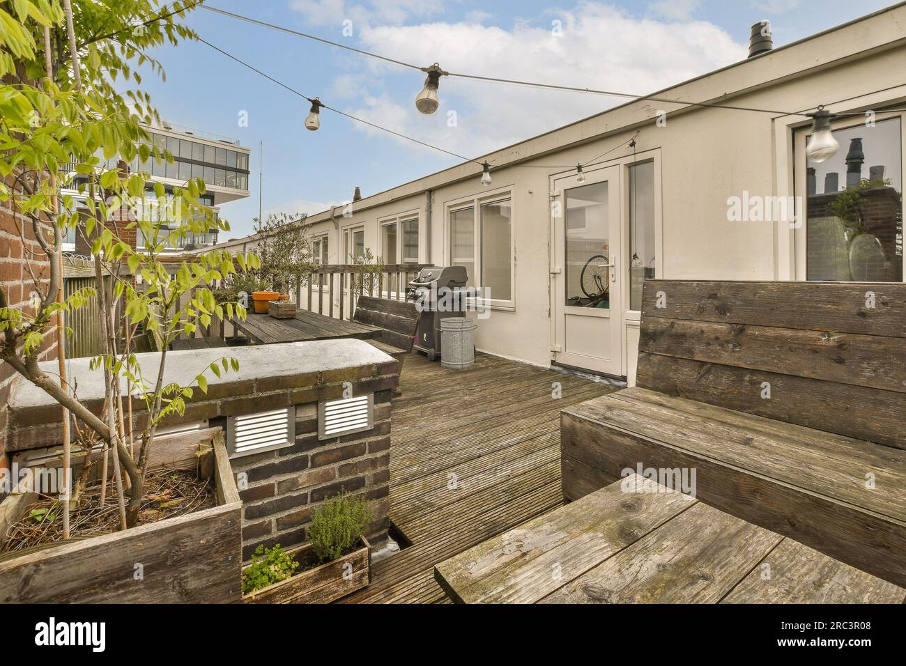 an outside area with wooden decking and white siding on the side of a ...