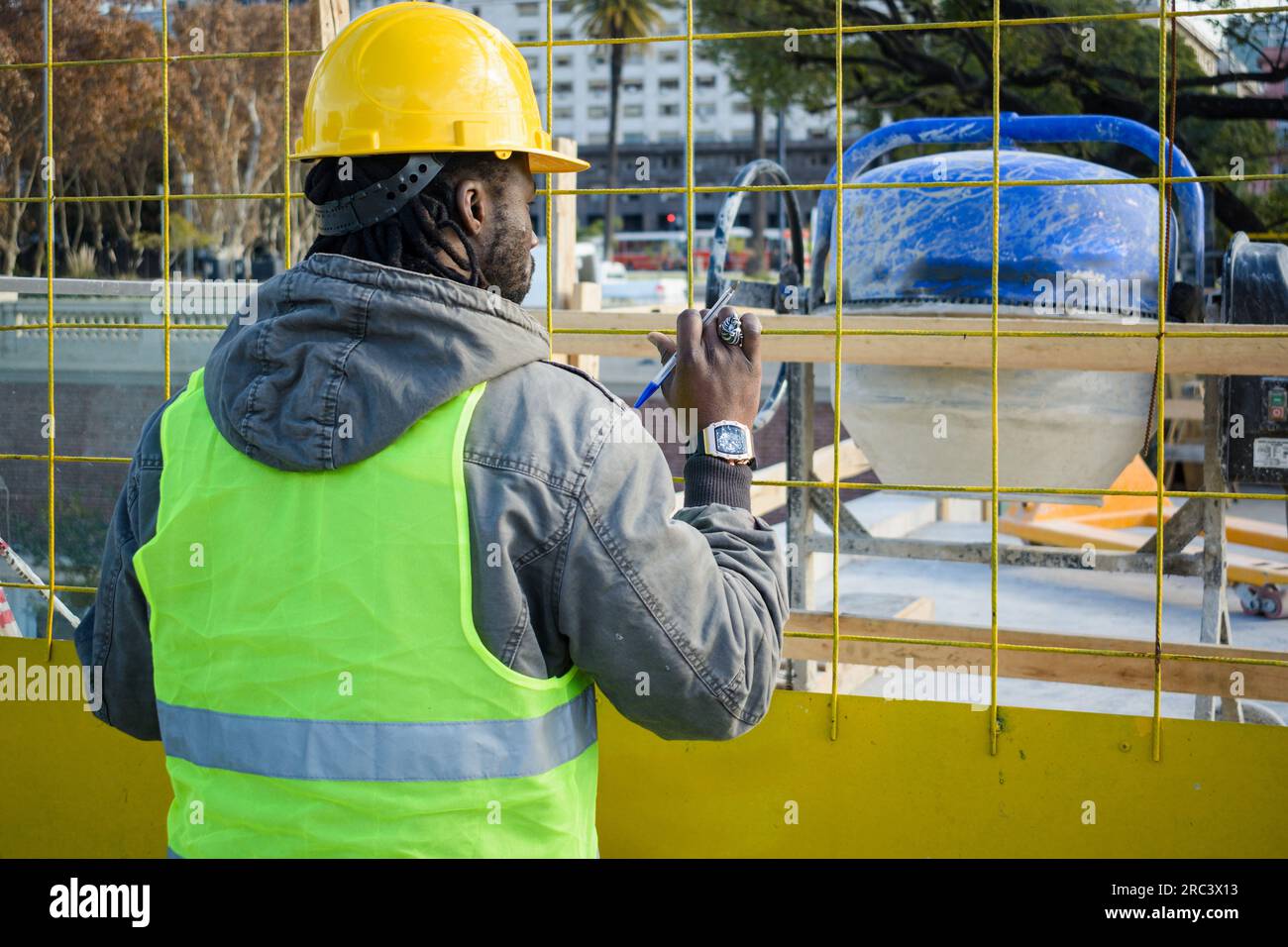 rear view of young black male civil engineer wearing vest and safety ...