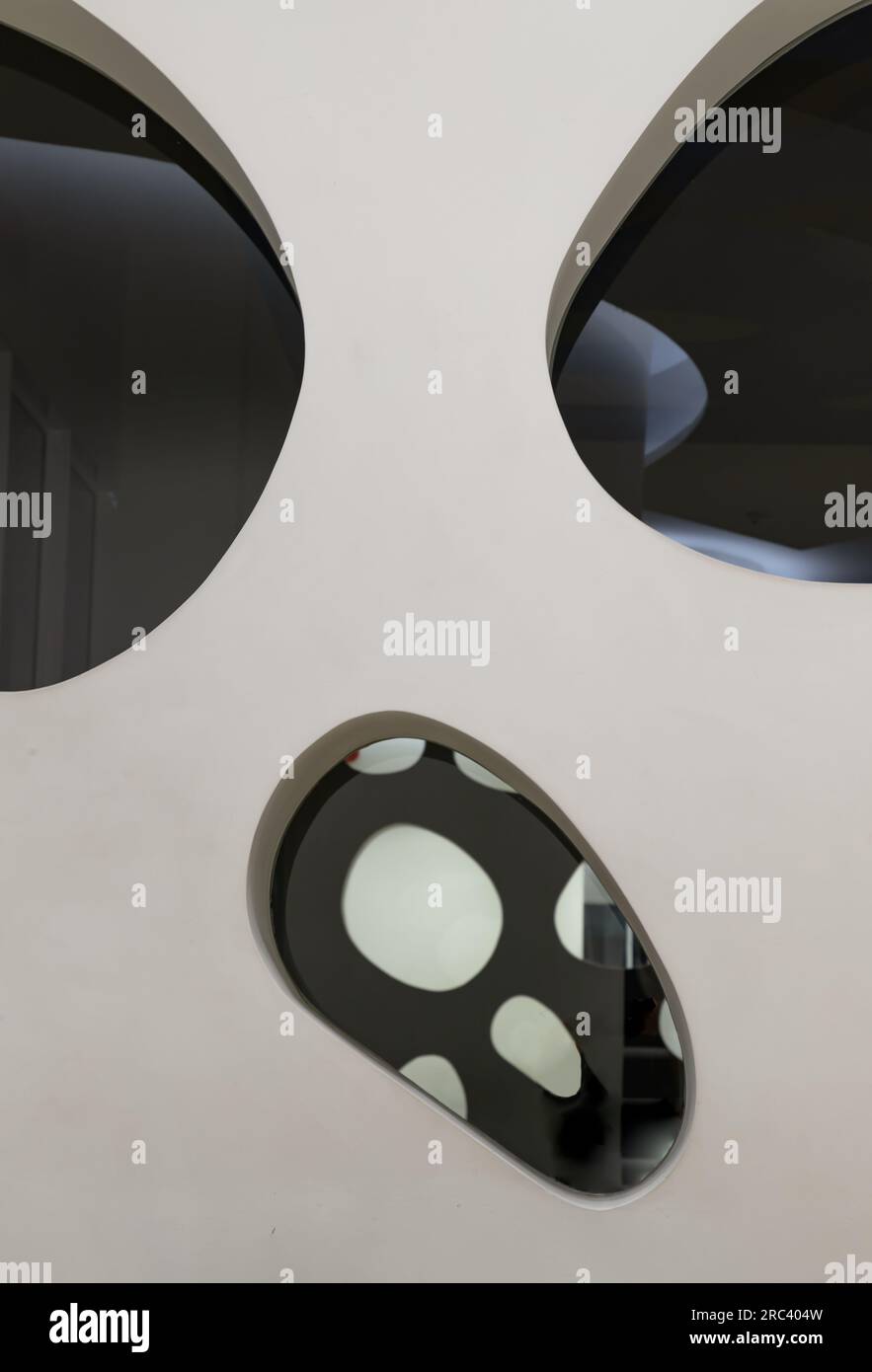 Glass mirrored panels are embedded in the white wall and are decorated ...