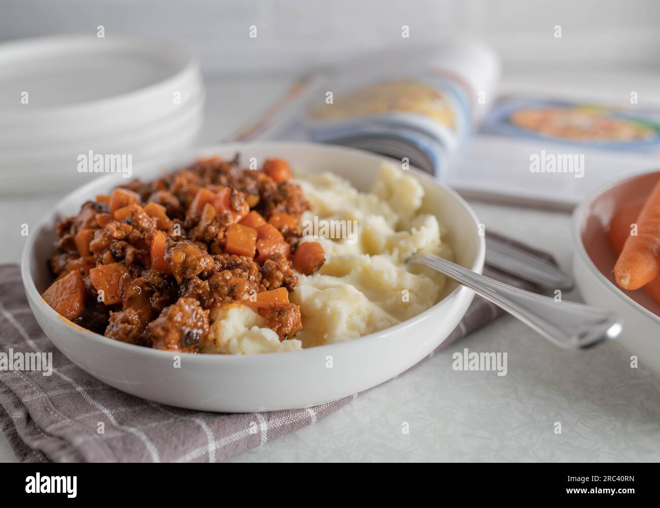 Plate with ground beef, carrots and mashed potatoes on kitchen counter ...