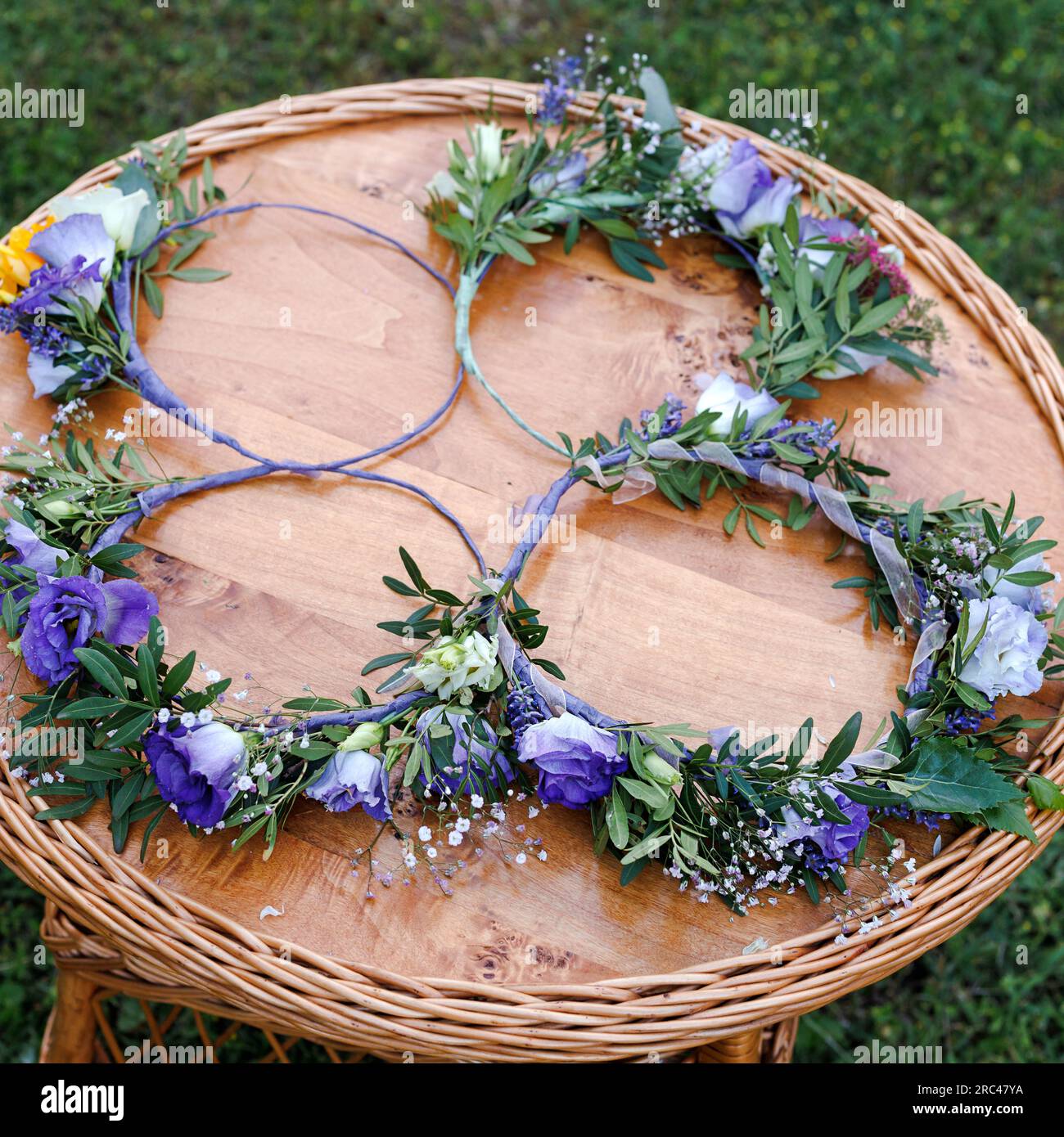 floral wreath of white and lilac eustoma on the wicker table in the ...