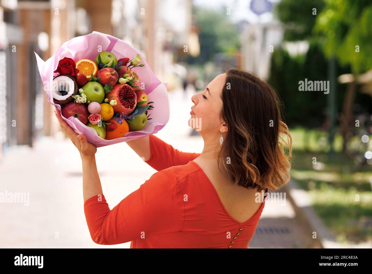 Young beautiful woman in a red dress holding an edible bouquet of ...