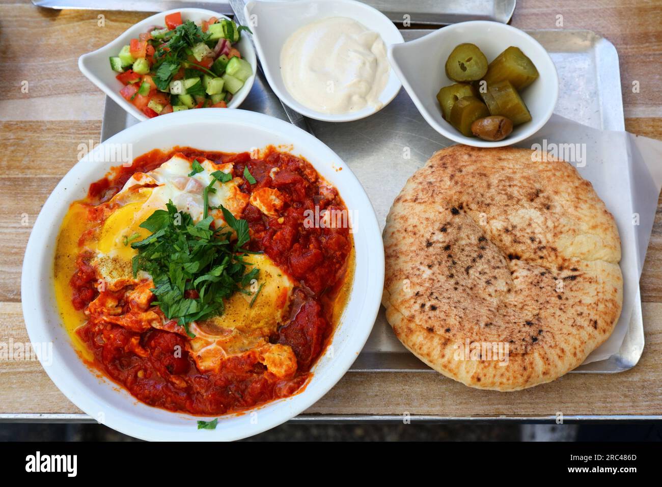 Israeli cuisine. Shakshuka lunch - poached eggs in spicy pan fried ...
