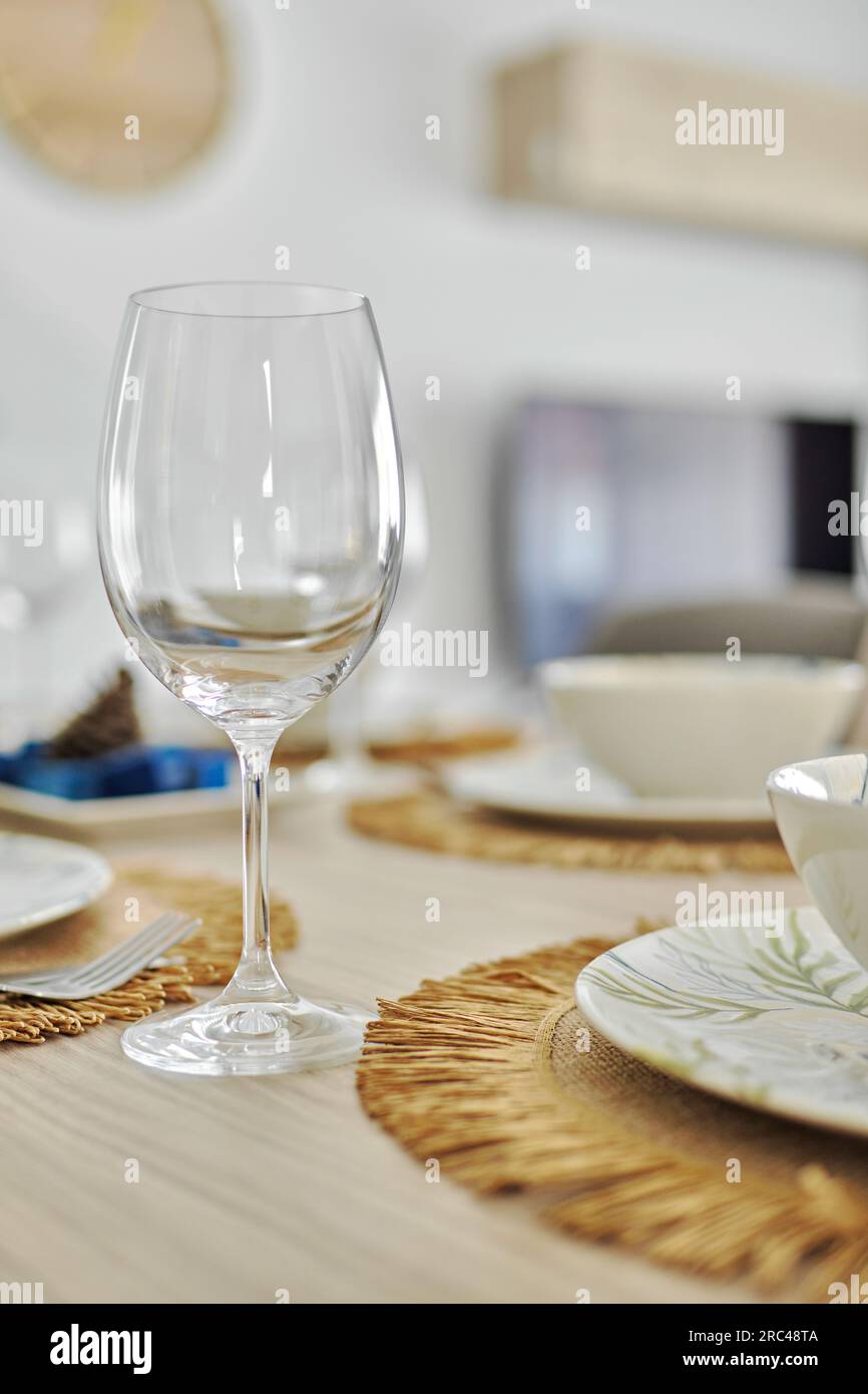 Vertical shot of empty wine glasses and dinnerware is ready for lunch ...