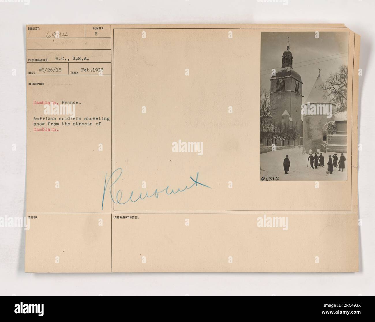 American soldiers in Damblain, France, clearing snow from the streets ...