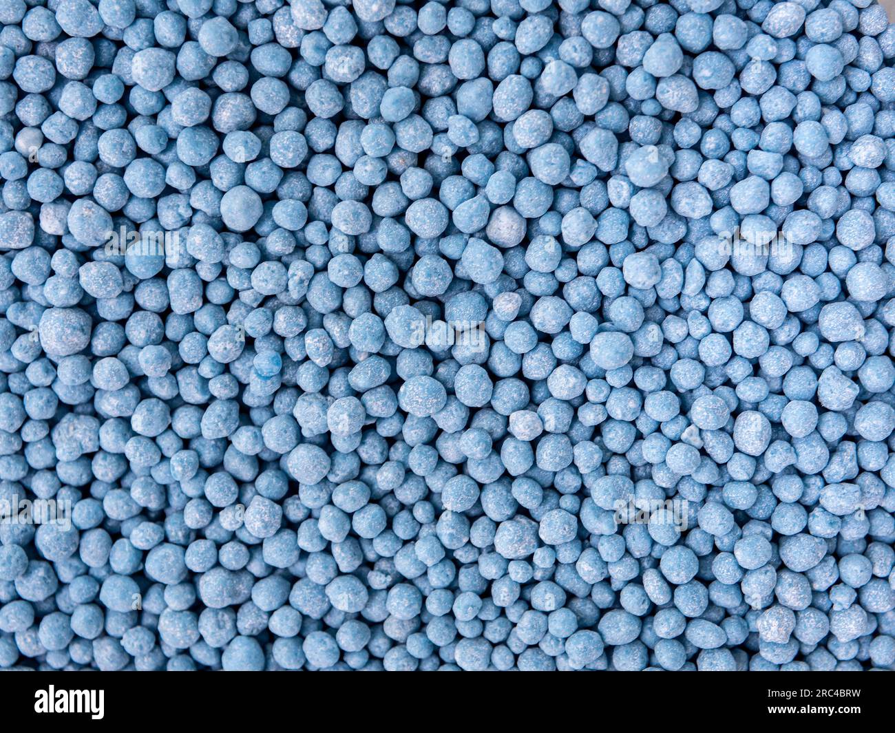 Small blue round granules are chemical fertilizers formulated to speed ...