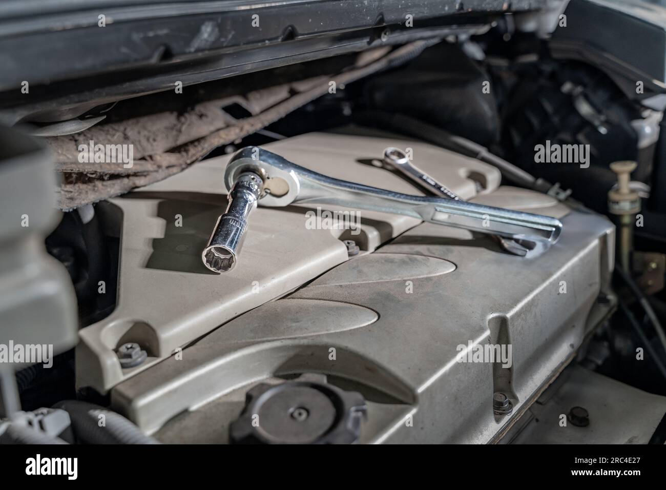 Close up of ratchet and fix wrench sitting on the car's engine Stock ...
