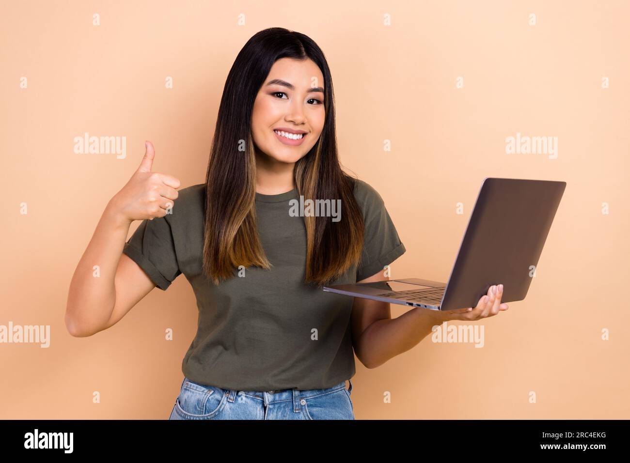 Portrait of charming person beaming smile use netbook demonstrate thumb ...