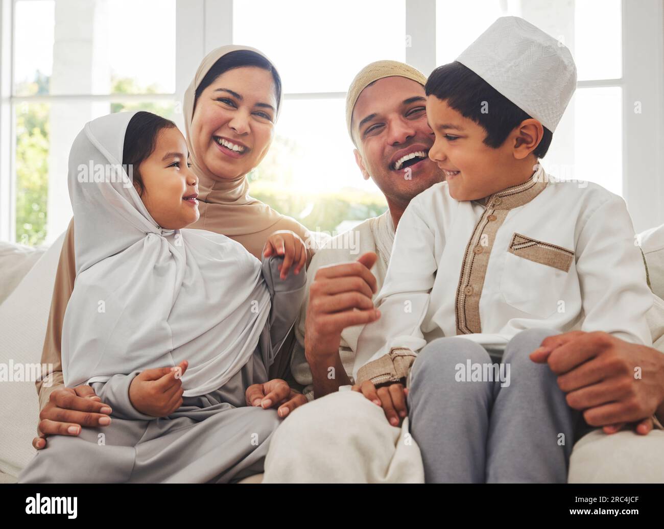 Happy family, Islam and laughing on couch for Eid with mom, dad and ...