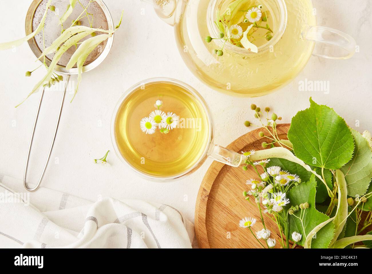 Teapot and cup with natural organic linden and chamomile tea blossoms ...