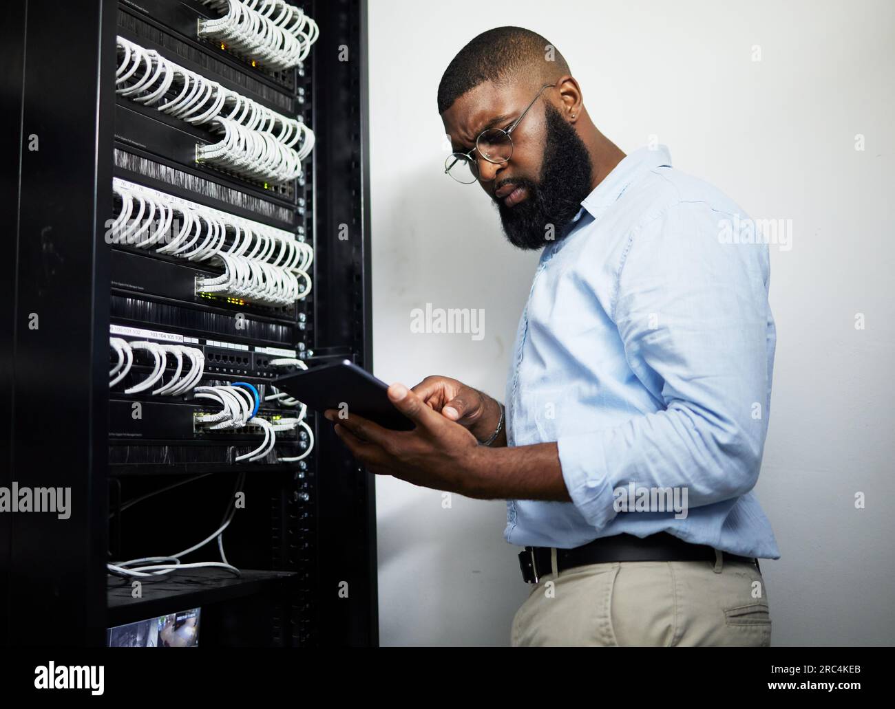 Data center, tablet and serious technician man with cables for internet ...