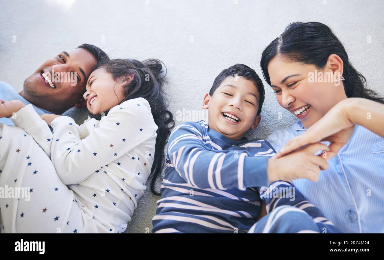 Family, laughing and play with fun and smile in a home with bonding and ...