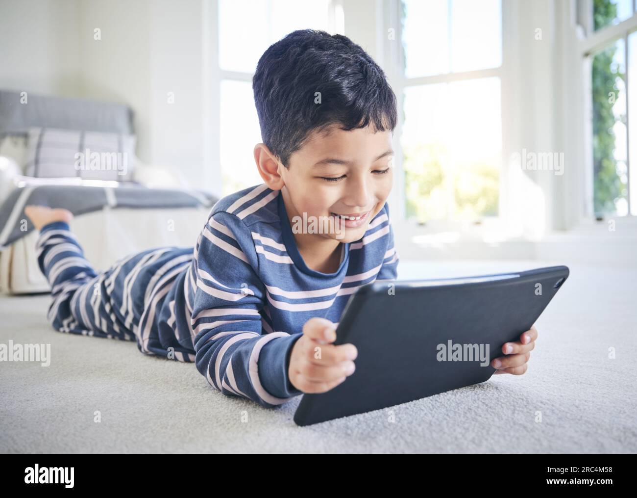 Young boy, tablet and games or cartoon streaming online with internet ...