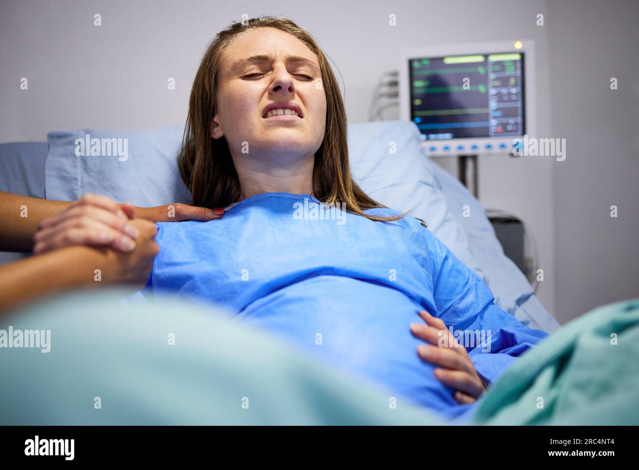 Pregnant woman, hospital and delivery with push, holding hands and ...