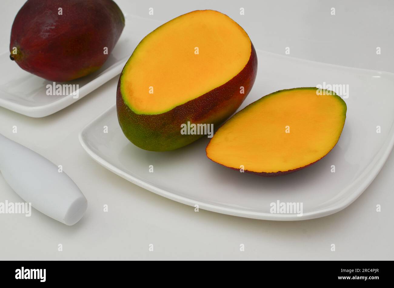 Ripe yellow mango cut into perfectly symmetrical slices, revealing its ...