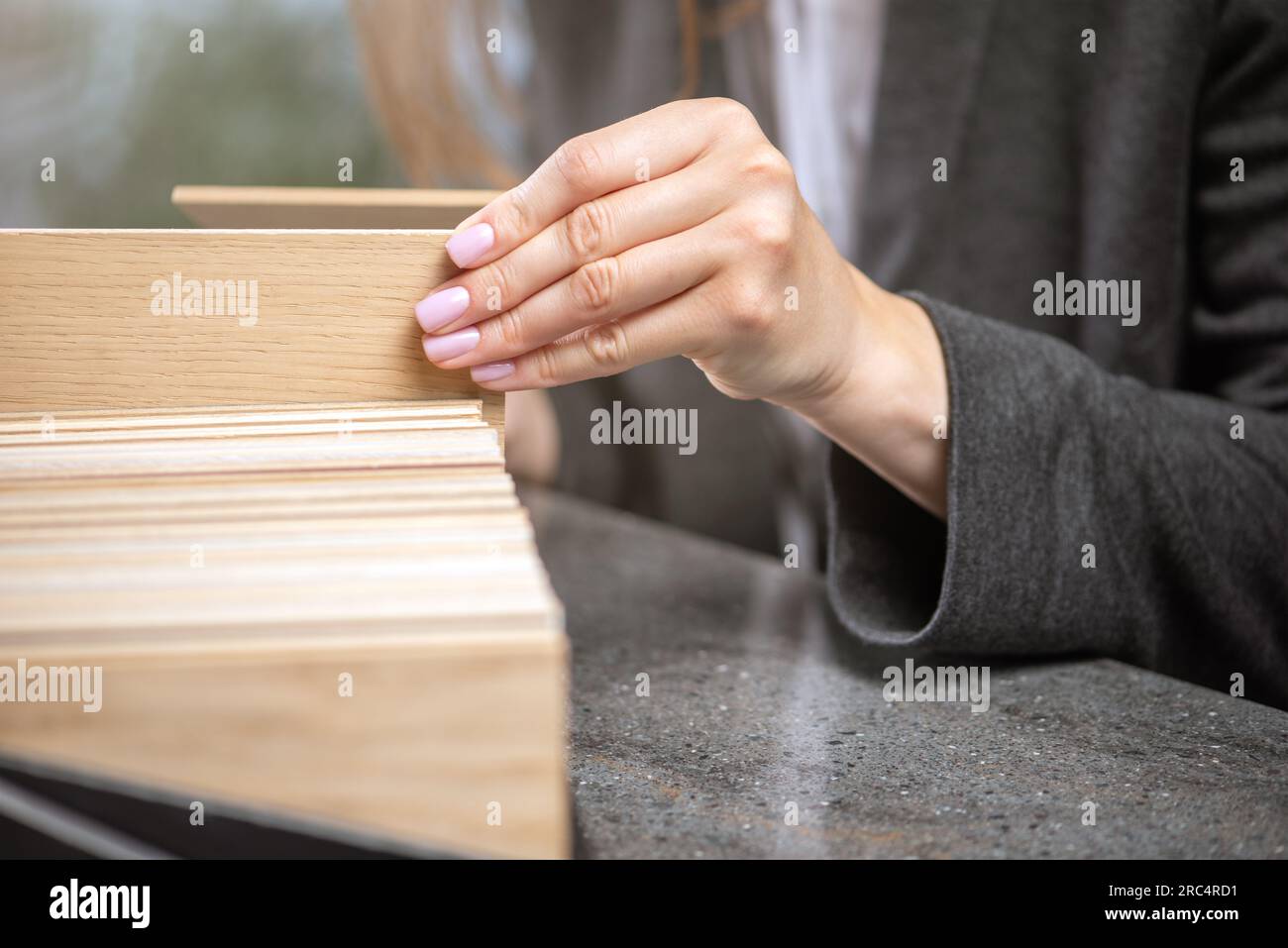 Choice of floor color. A woman chooses a shade of wood floor color ...