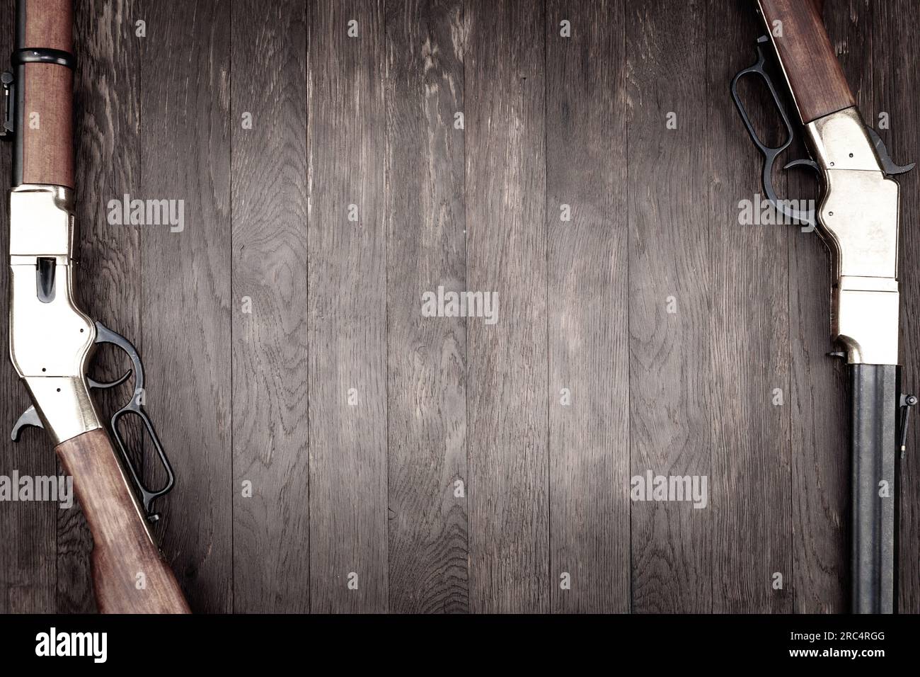 Old west guns. Lever-action repeating rifles with ammunition on wooden ...