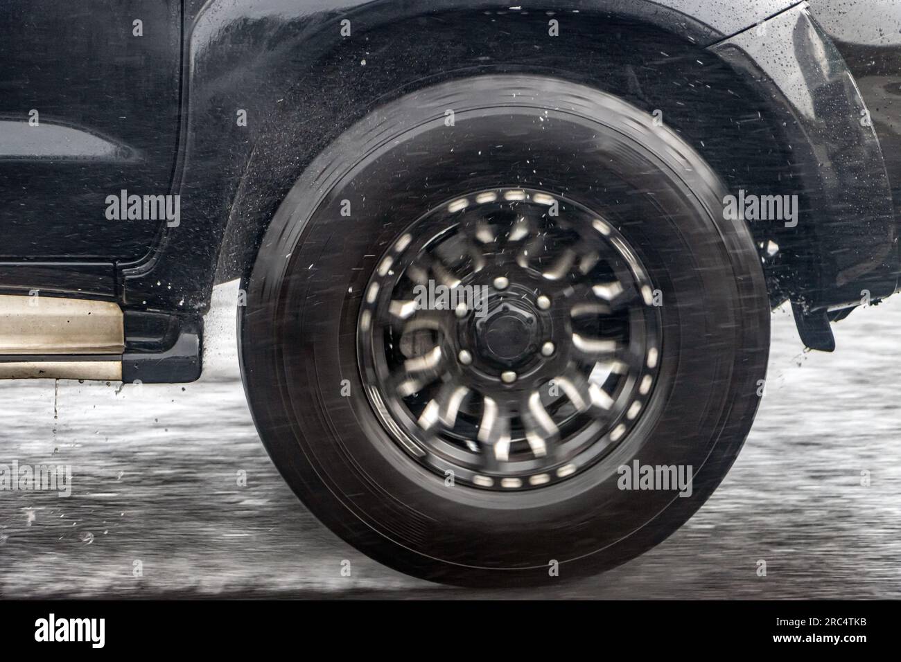 Detail of the wheel of a car driving in the rain on a wet road Stock ...