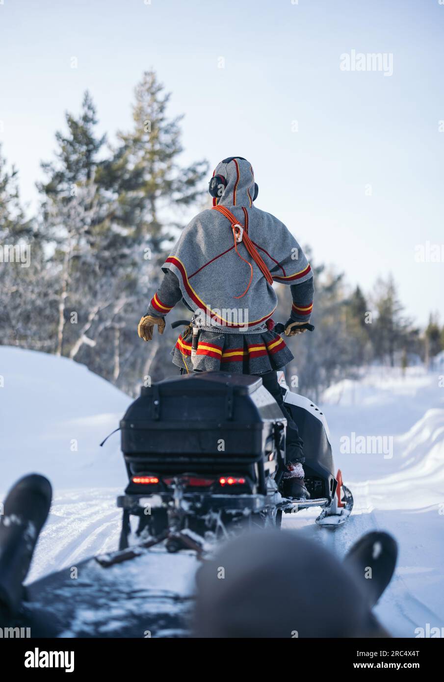 Back view unrecognizable authentic person in gakti riding snowmobile on ...