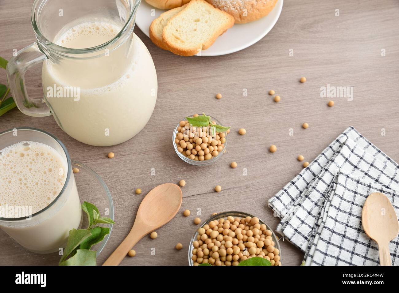 Soy milk in a glass and jug for alternative breakfast with bowls full ...