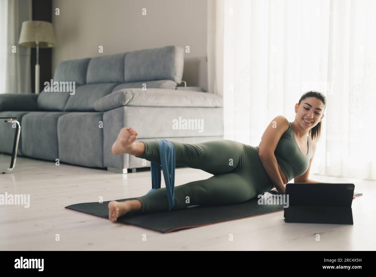 Side view of slim barefoot smiling young female lying on mat in plank ...