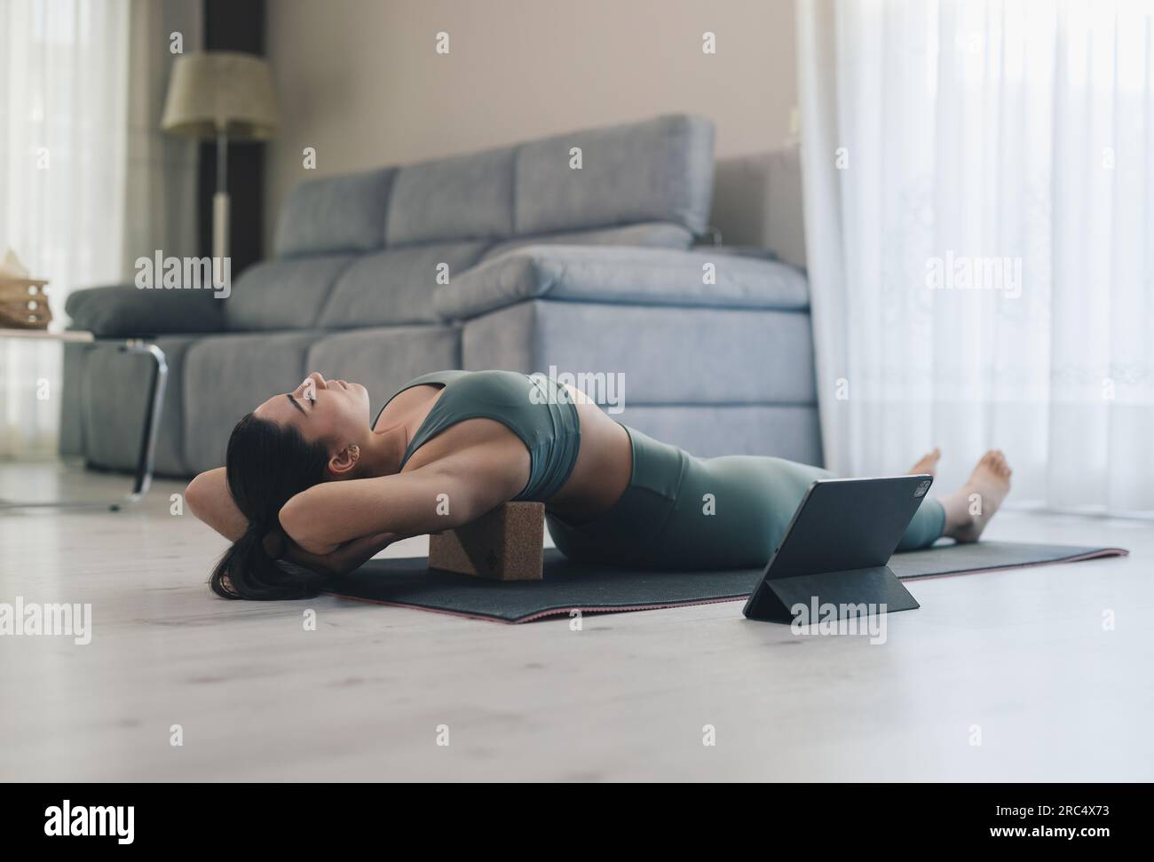 Side view of flexible young female in sportswear performing Matsyasana ...