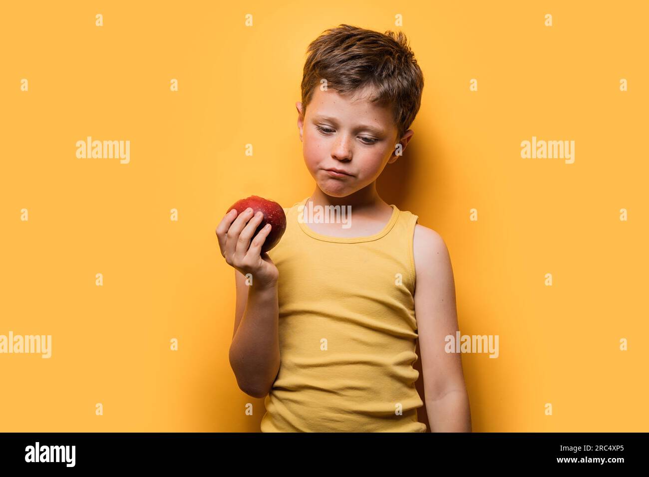 Portrait of moody boy in yellow casual outfit making sad face and ...